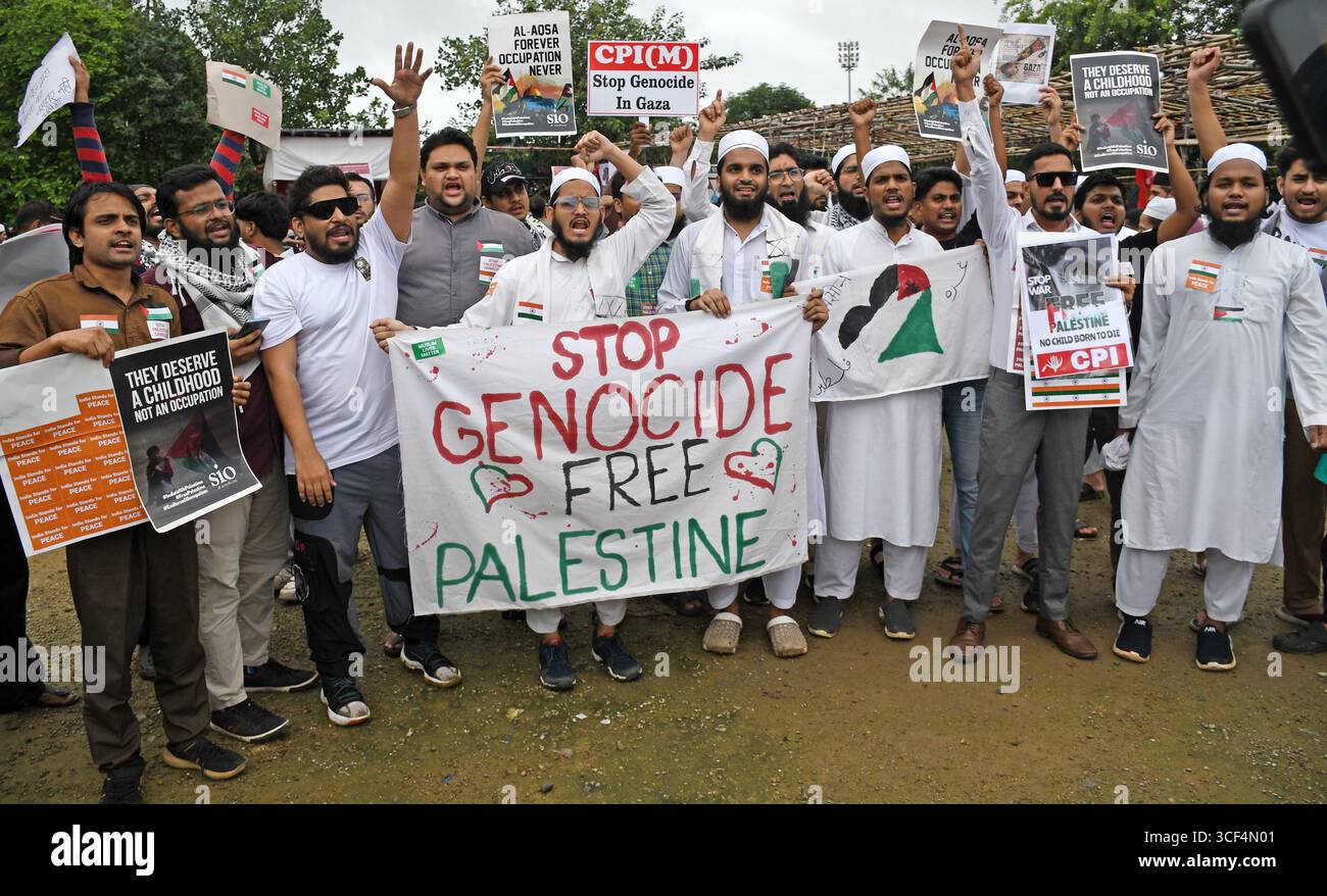 Muslim men shout slogans while holding a banner with inscriptions 'Stop ...