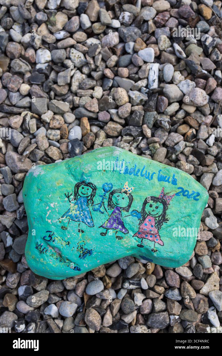 Colorfully painted stone at the edge of the path becomes a trendy sign ...
