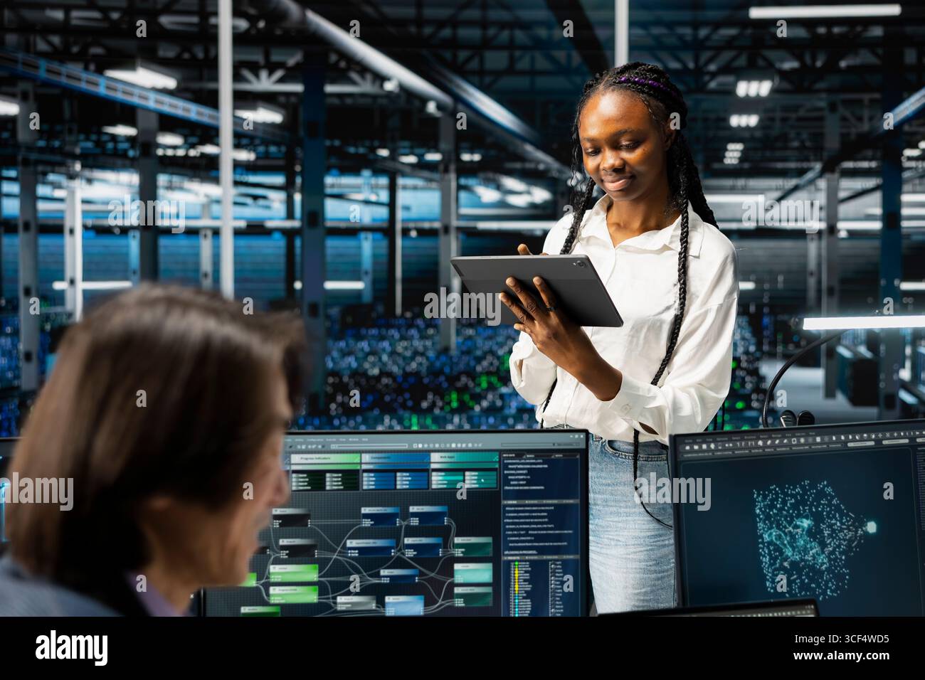 Smiling data center software developer using tablet, coding, managing systems for uptime and ...