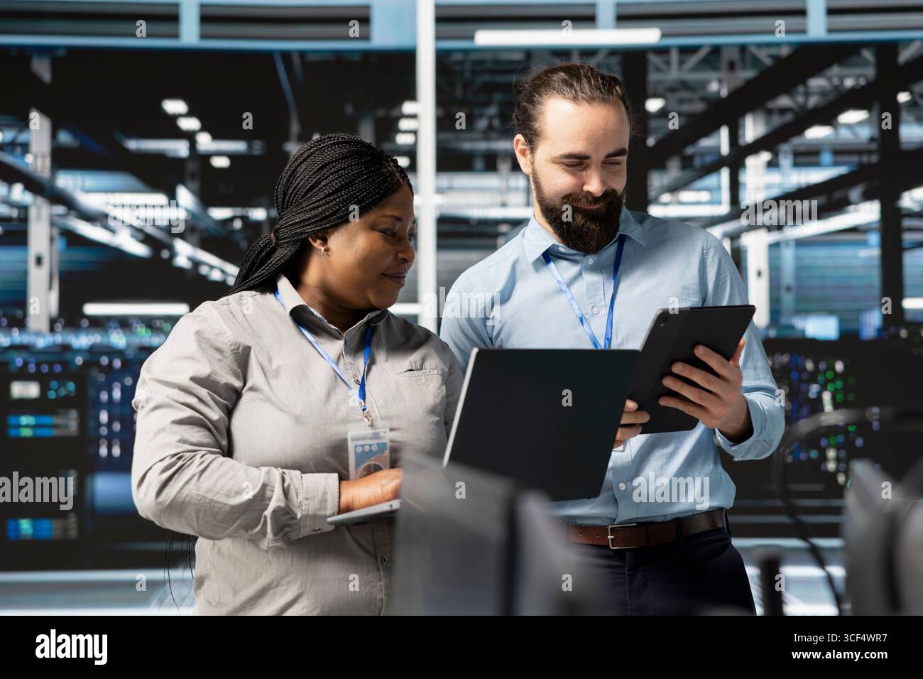 Happy system administrators in data center using devices, verifying firewall configurations ...