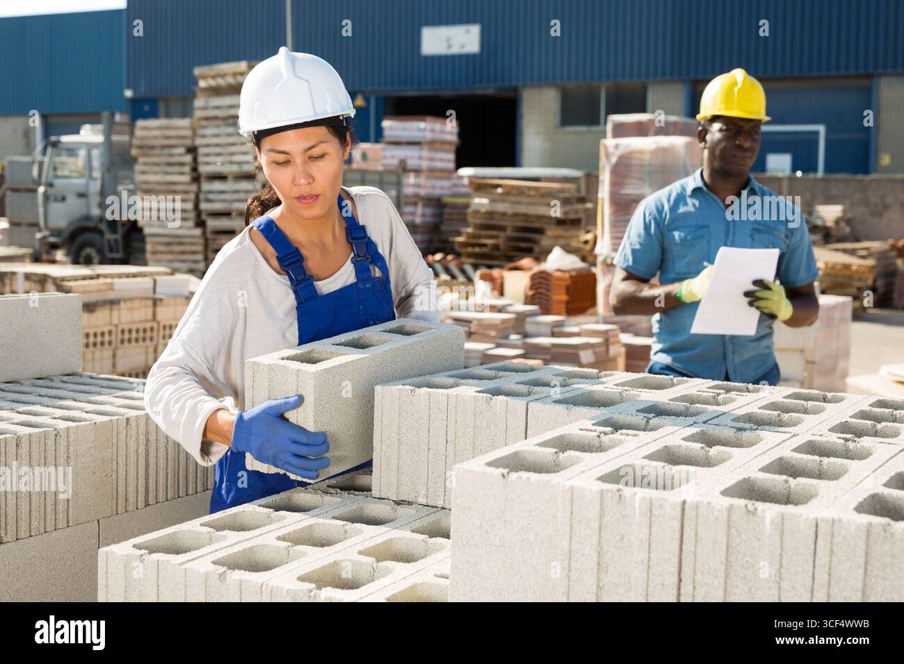 Asian worker stacking bricks in warehouse of building materials on an ...