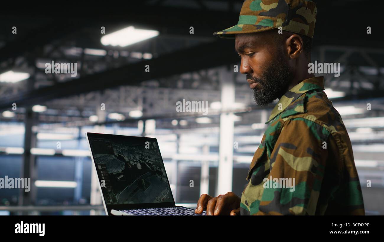 Drone operators in military data center supervising autonomous flight systems through laptop ...