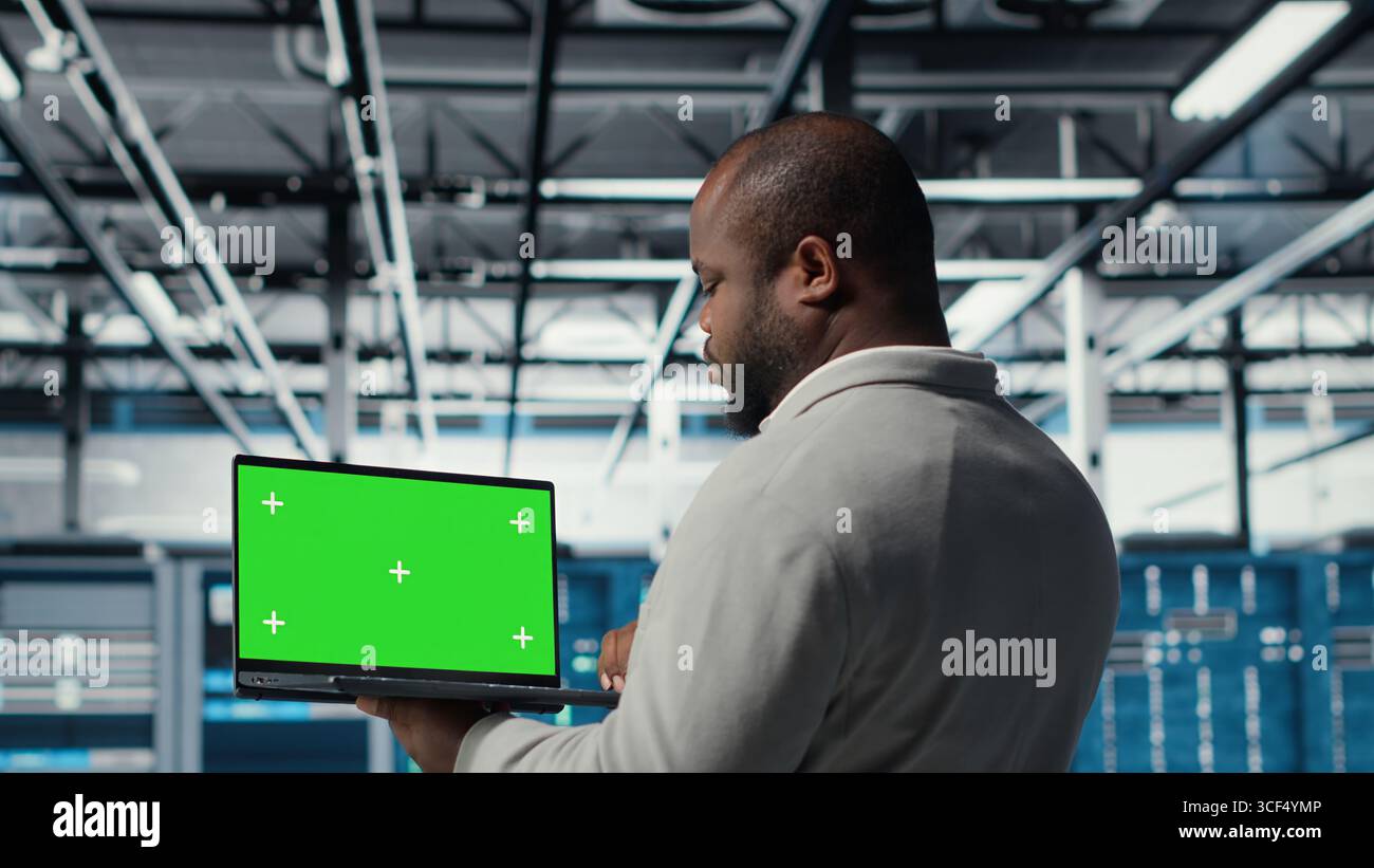 Data center admin using isolated screen laptop to monitor neural ...