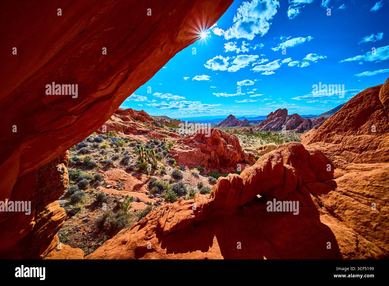 Desert Arch Framing Red Rock Landscape and Sunburst in Rugged Southwest ...