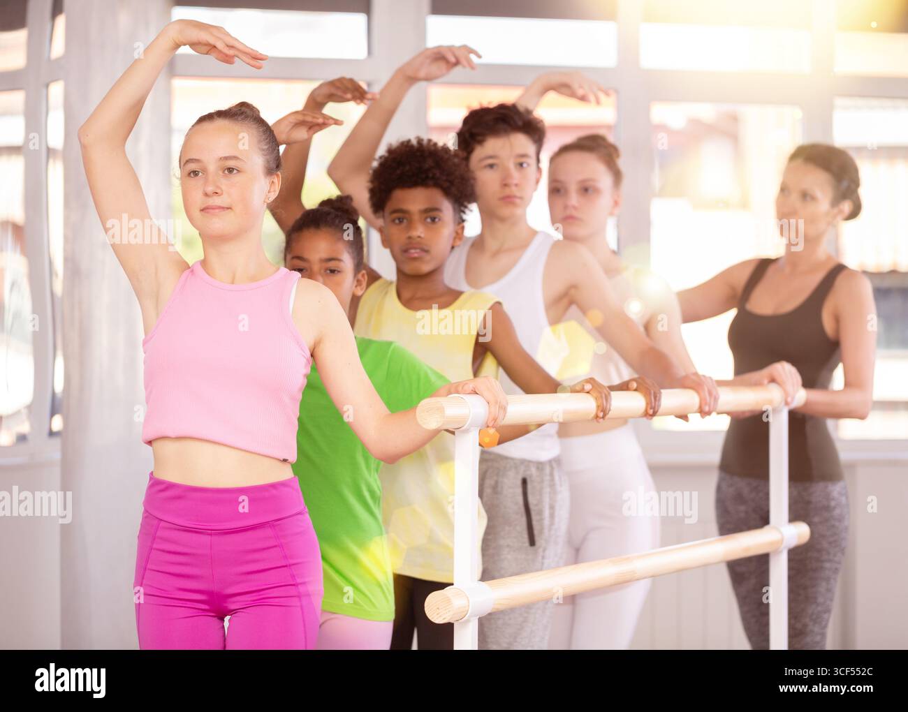 Teen girl learning third ballet position in beginner class Stock Photo ...