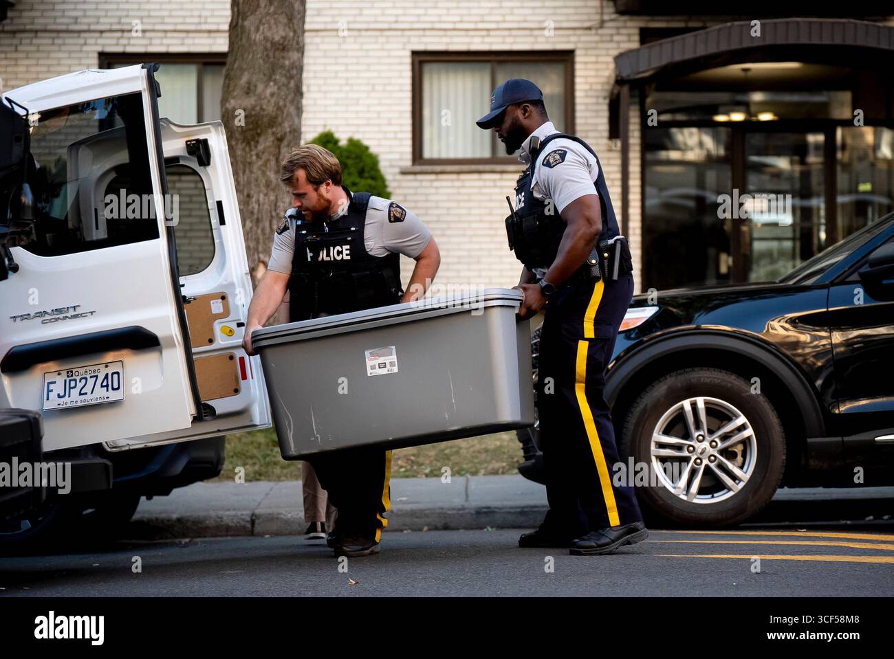 RCMP personnel remove items from an apartment during an active ...