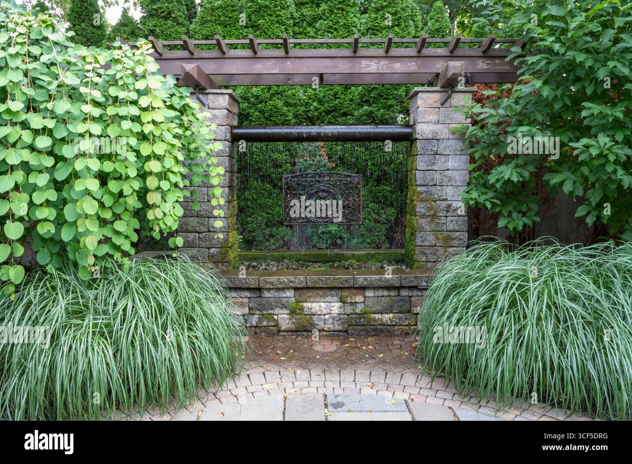 Framed iron waterfall feature with wood pergola and stone pillars ...