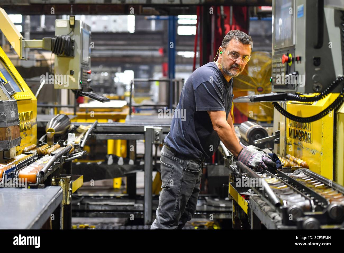 An employee at General Dynamics waits for a shell on the line. (Photo ...