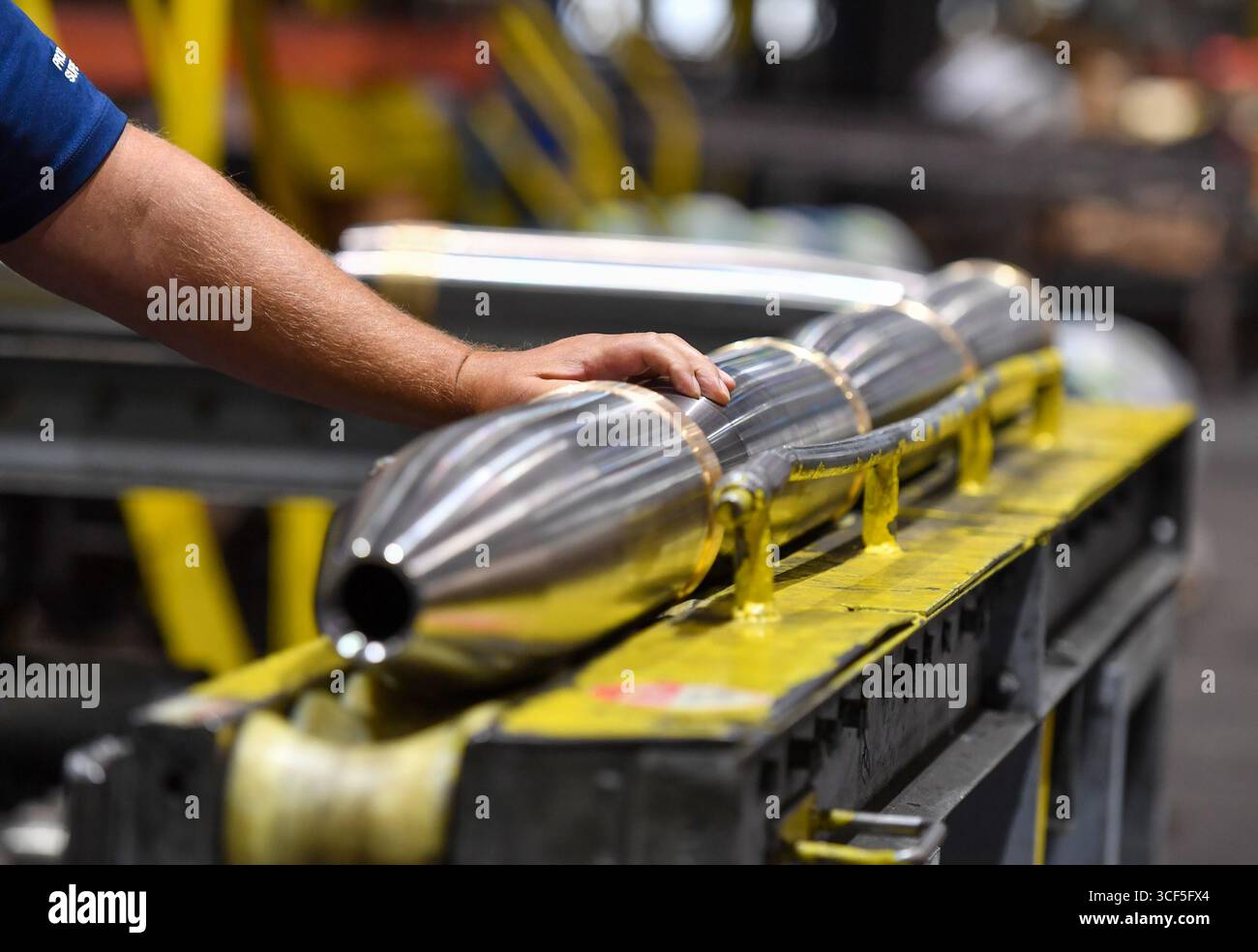 Mortar shells move along a conveyer at General Dynamics. (Photo by ...