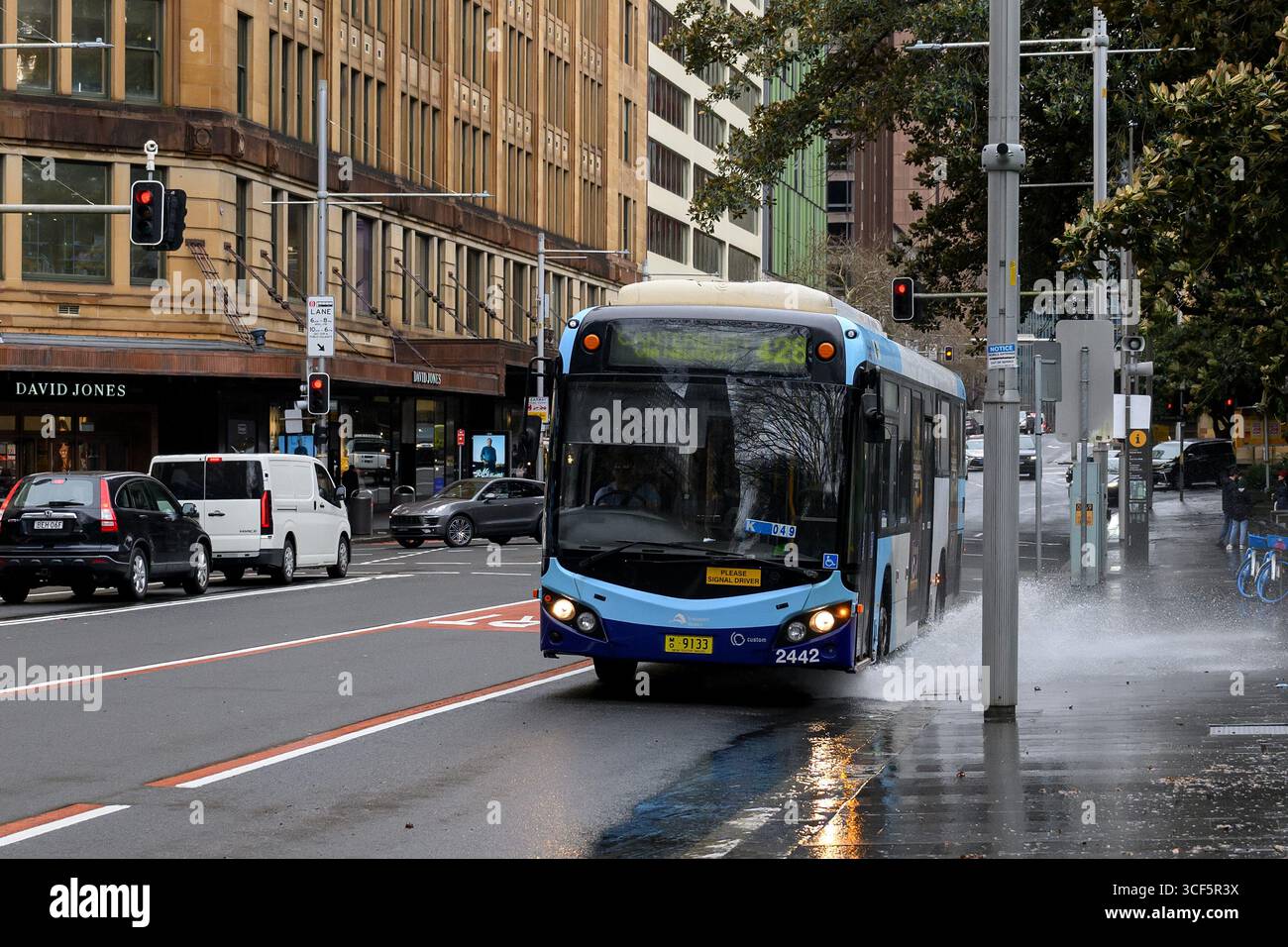 A bus drives through a puddle of water in Sydney, Thursday, August 21 ...
