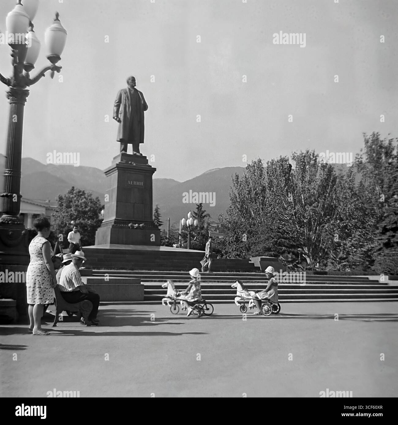Children ride bicycles and pedal horses in the central square near the ...