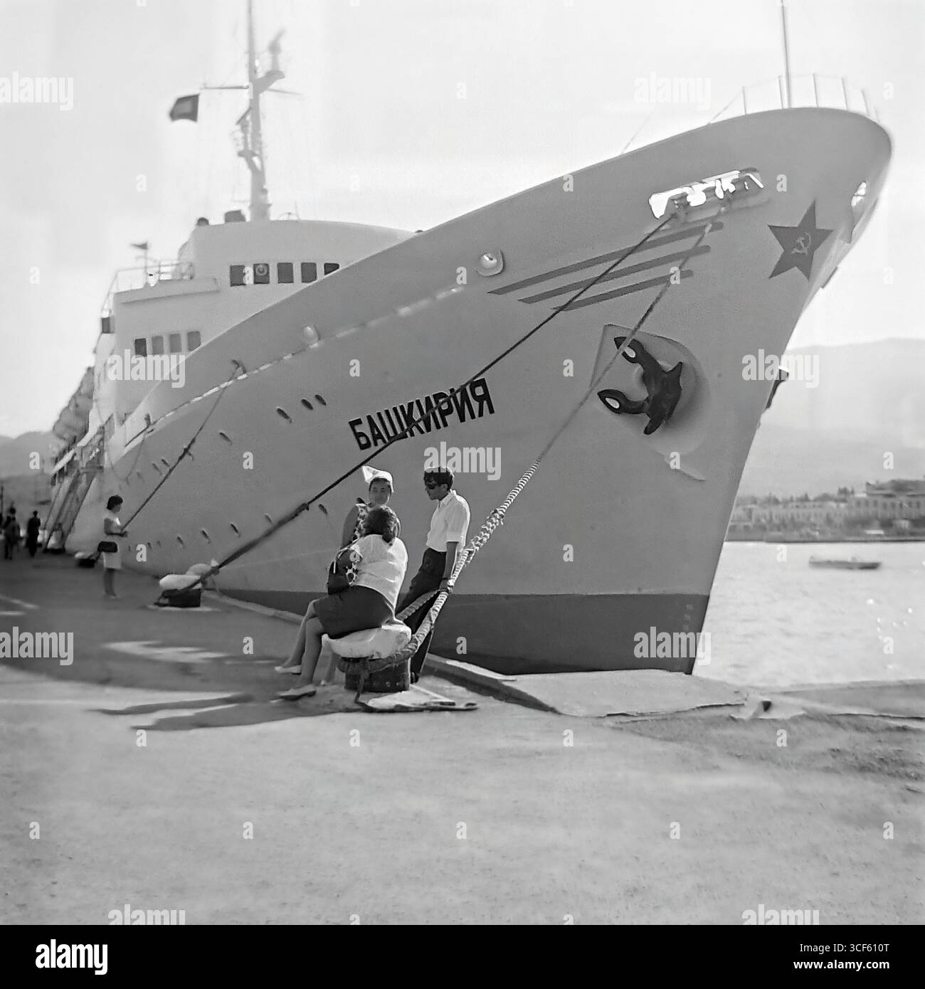 Passengers relax on a pier in the port of Yalta by the bow of the ...