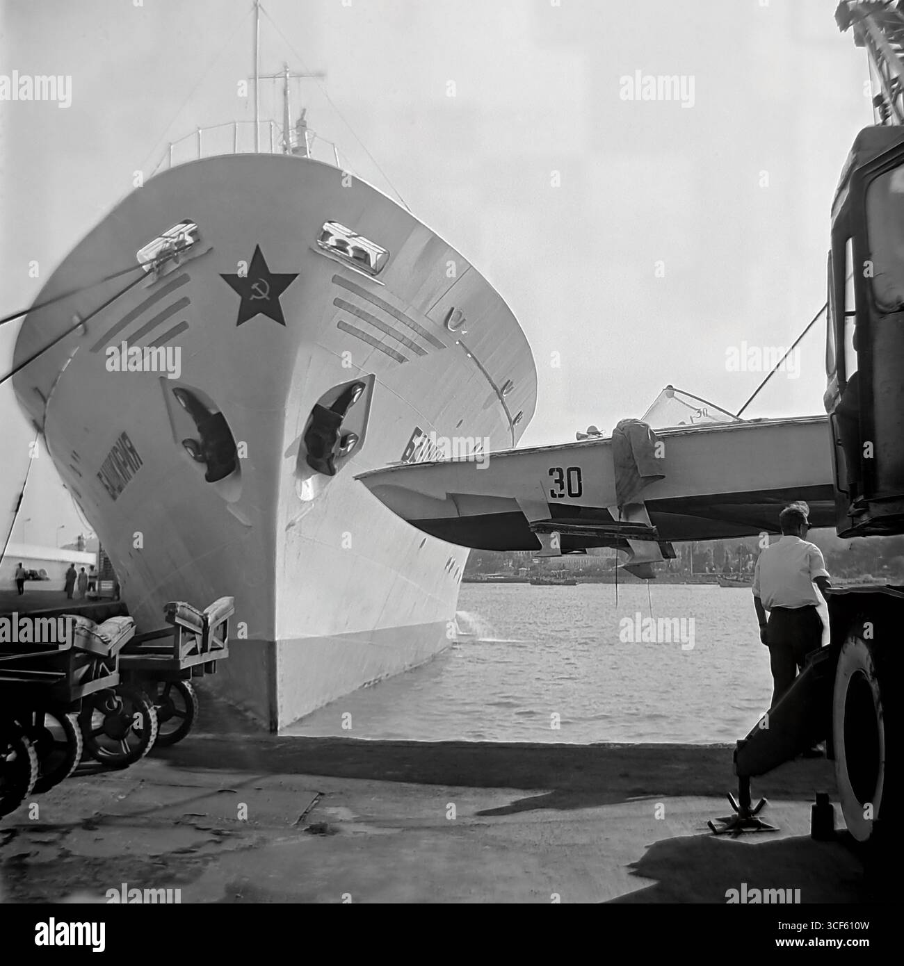 A port crane moves a hydrofoil against the backdrop of the cruise liner ...