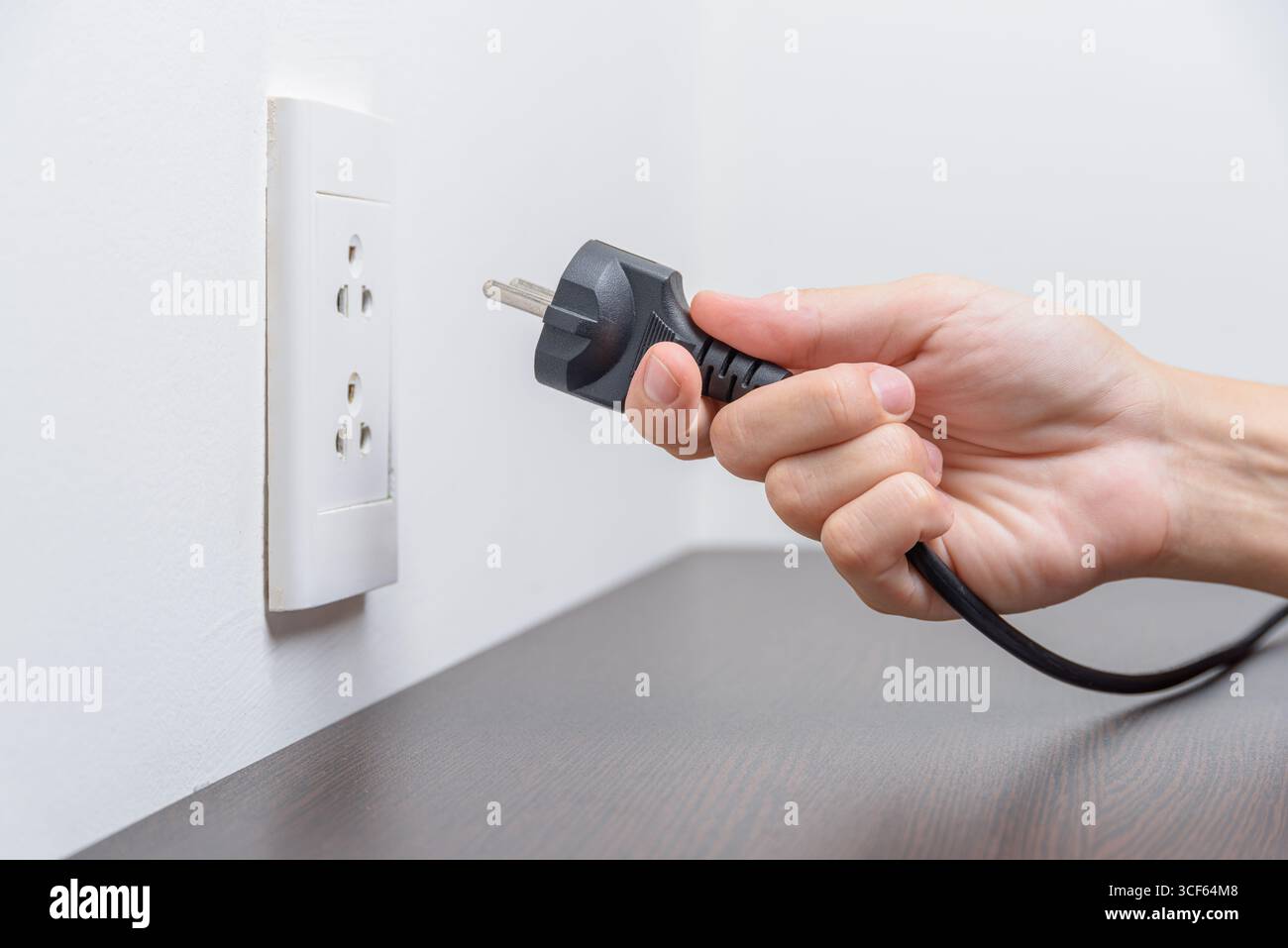 Closeup hand inserting black electric hi-res stock photography and ...