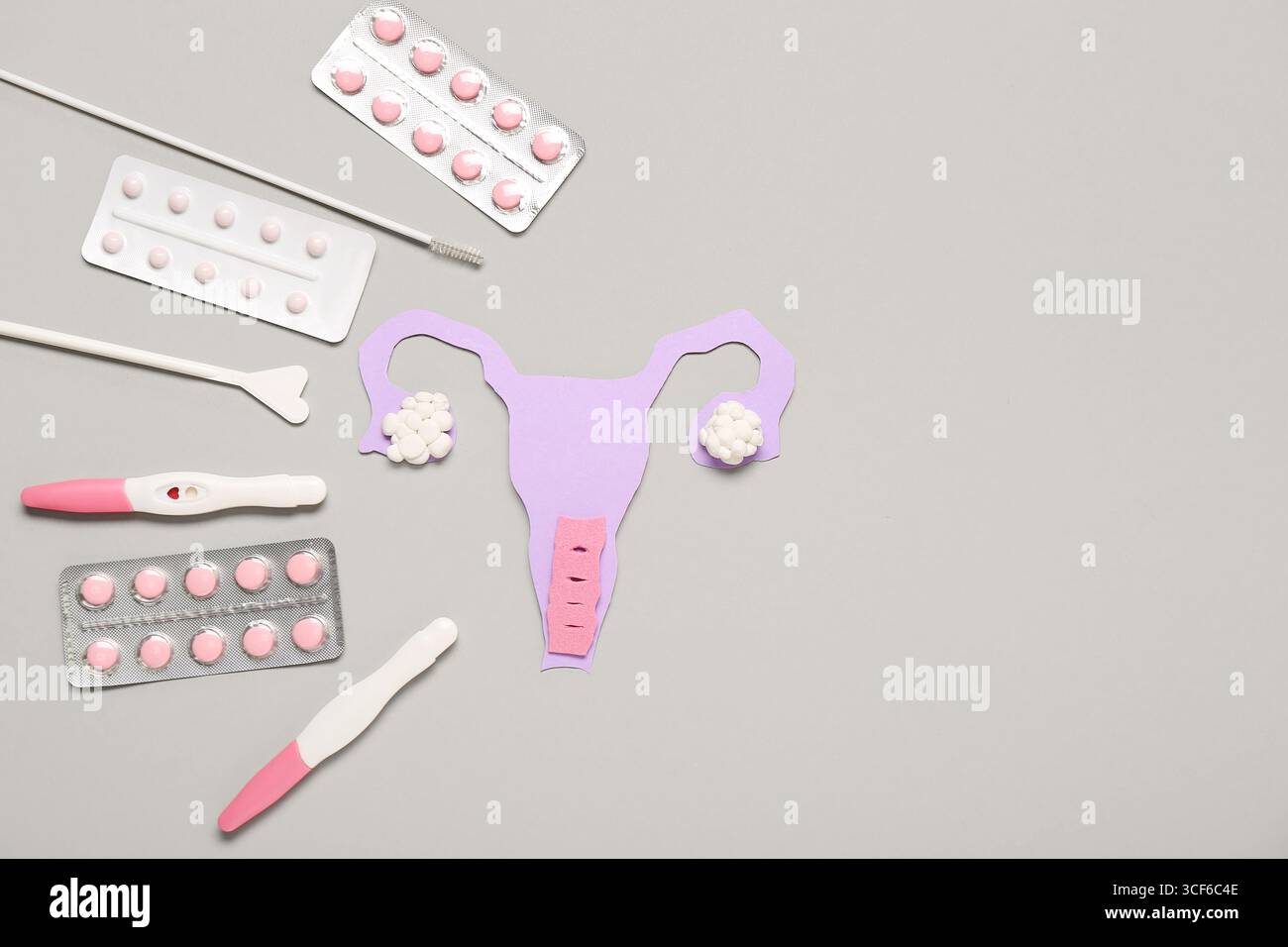 Paper uterus with pregnancy tests and pills on grey background Stock ...