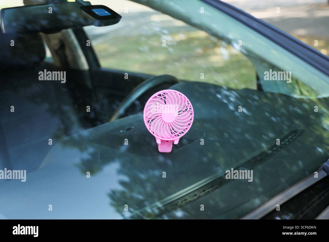 Mini electric fan on car dashboard, view through windshield Stock Photo ...