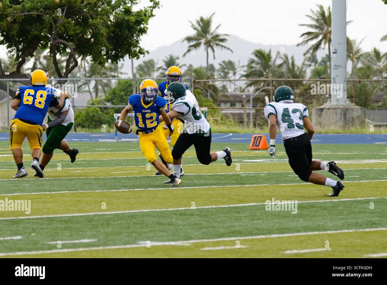 With defenders on his heels, the Kaiser quarterback sprints for yardage ...