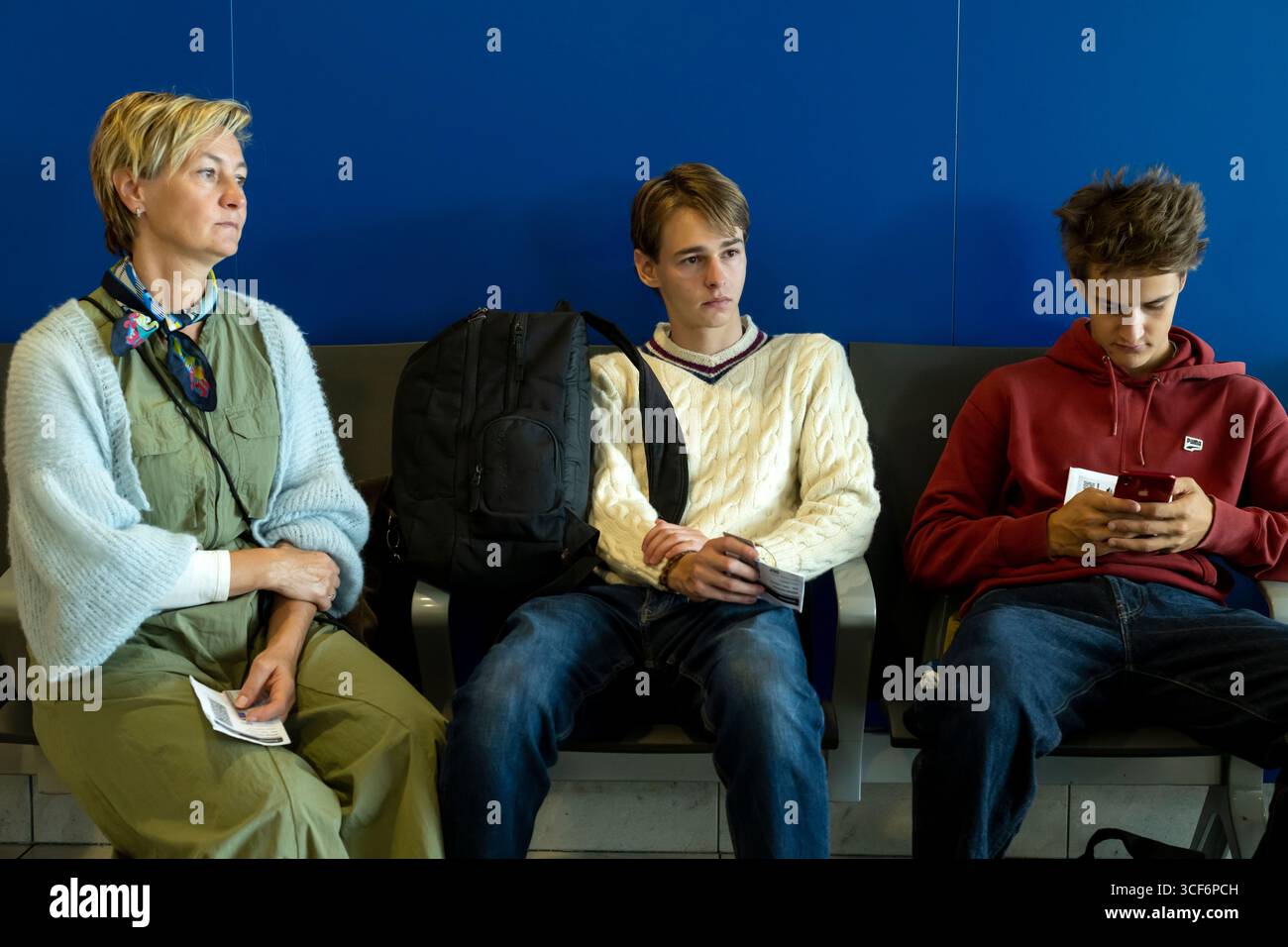 family of three is boring while waiting for the plane Stock Photo - Alamy