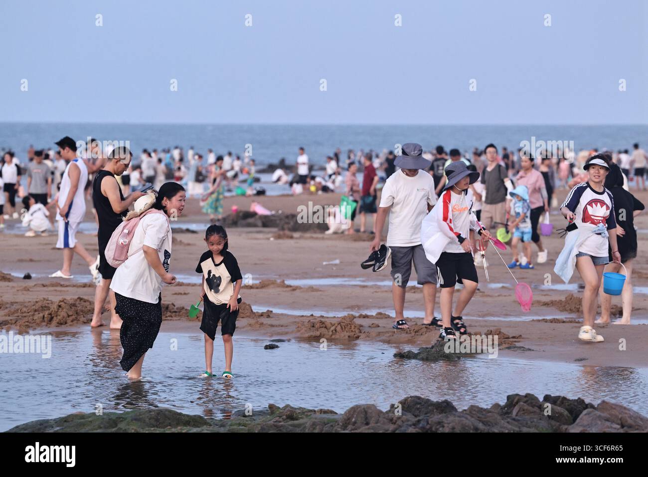 People go beachcombing in Rizhao City, east China's Shandong Province ...