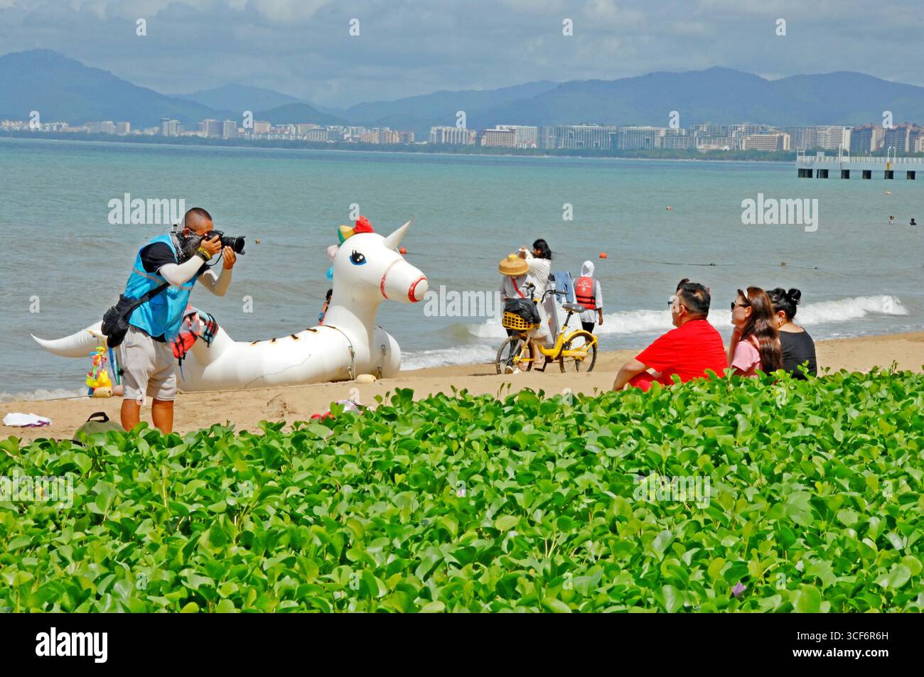 Tourists play at the seaside in Sanya City, southernmost China's Hainan ...