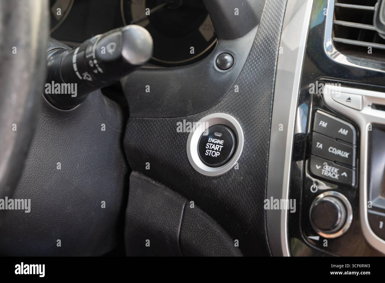 A closeup view of a cars ignition startstop button illustrates the ...