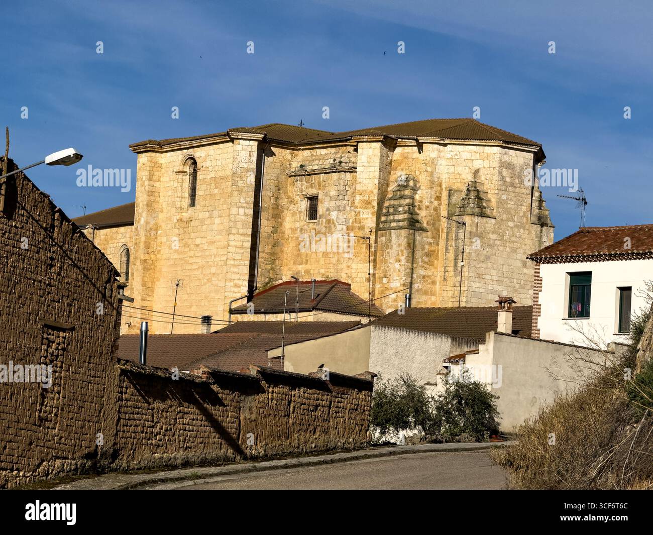 Old adobe houses on a narrow road leading to a historic church in ...