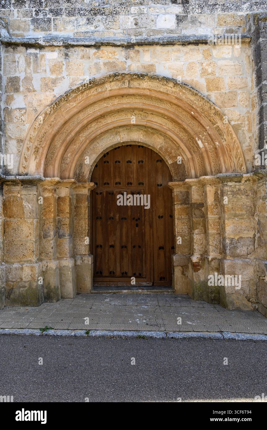 Ancient Romanesque church facade with round arch entrance and stone ...