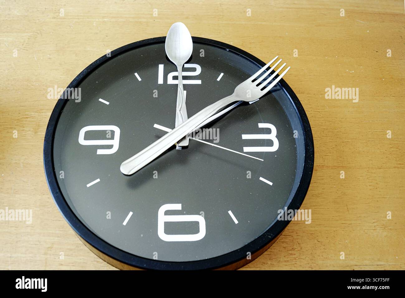 Intermittent fasting concept: fork and spoon on clock face representing ...