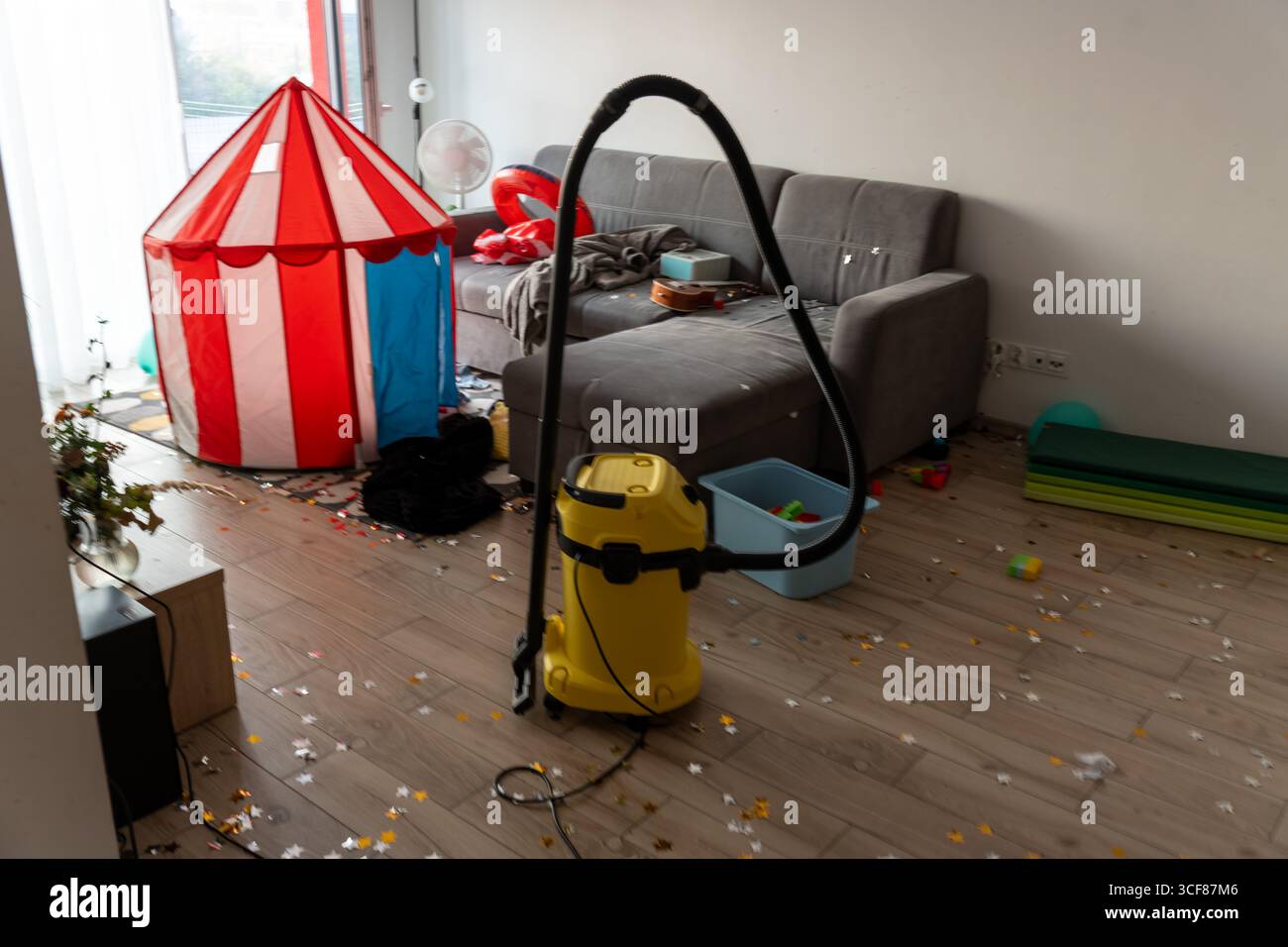 Yellow wet dry vacuum cleaning child playroom with circus tent toy and ...