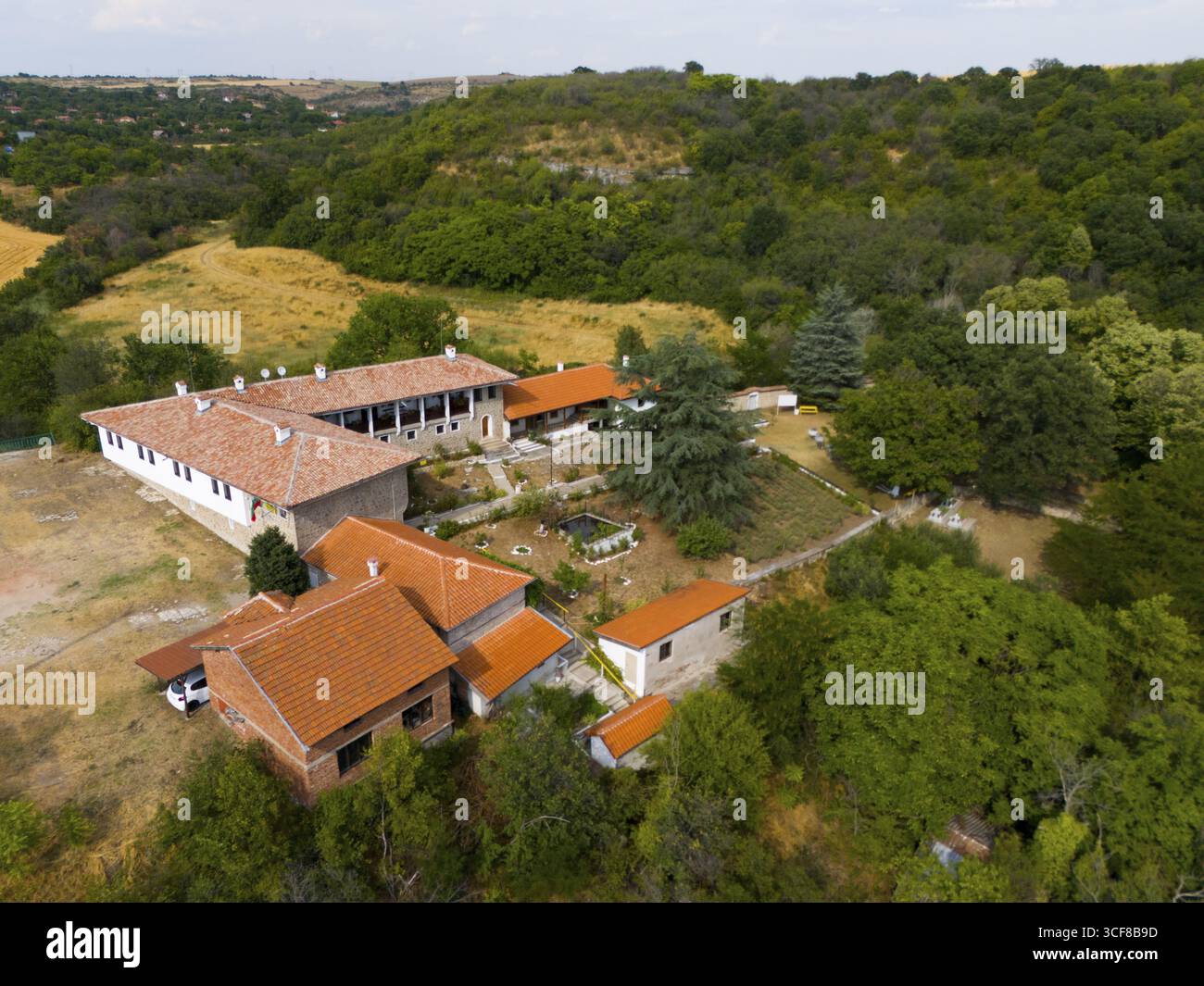 Rural scene with scattered houses and red roofs surrounded by green ...