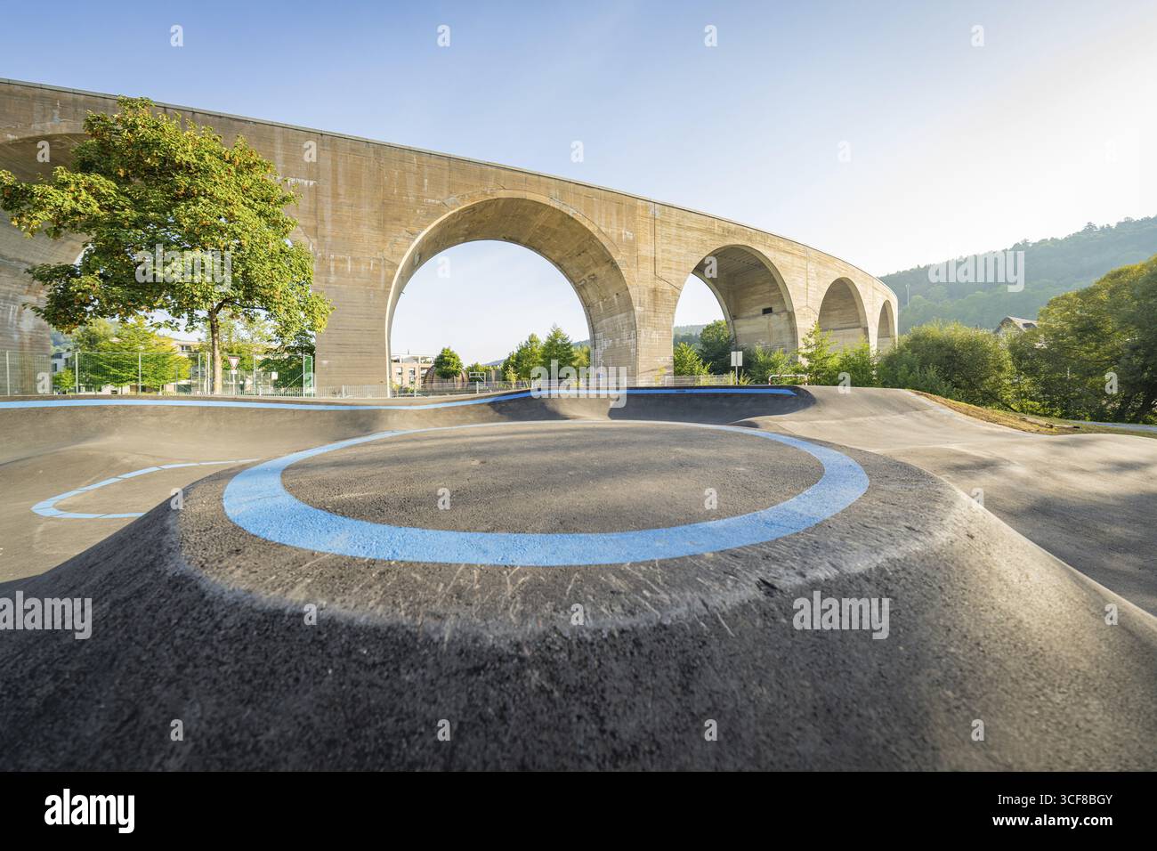 Open asphalt surface with bridge, blue markings and natural ...