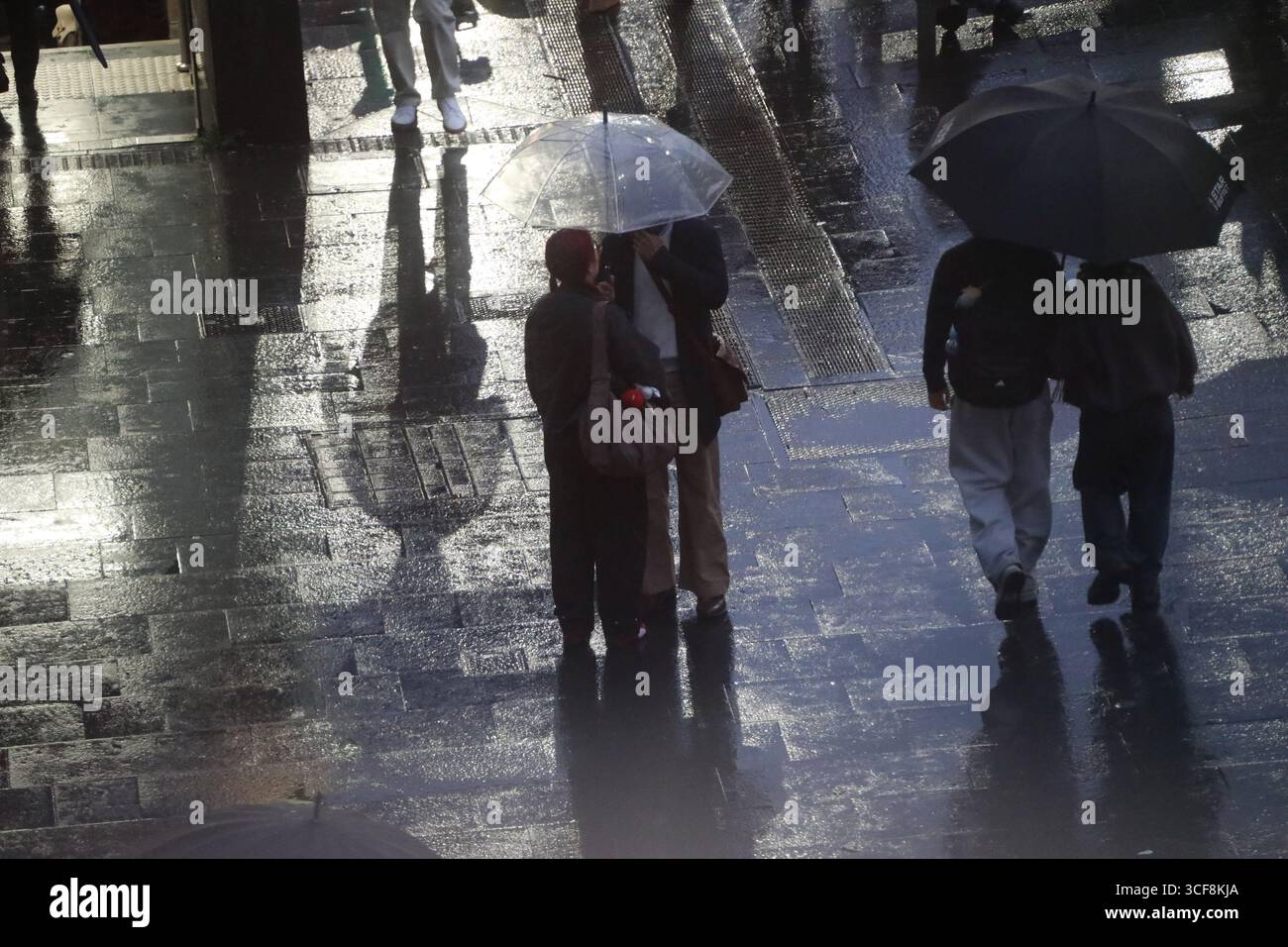 Sydney, NSW, Australia. 21st August 2025. People with an umbrella in ...