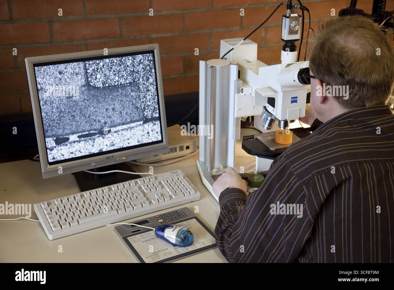Welding engineer examining material sample with the microscope ...