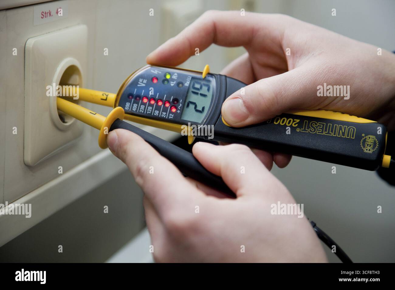 Voltage tester testing a power point Stock Photo - Alamy