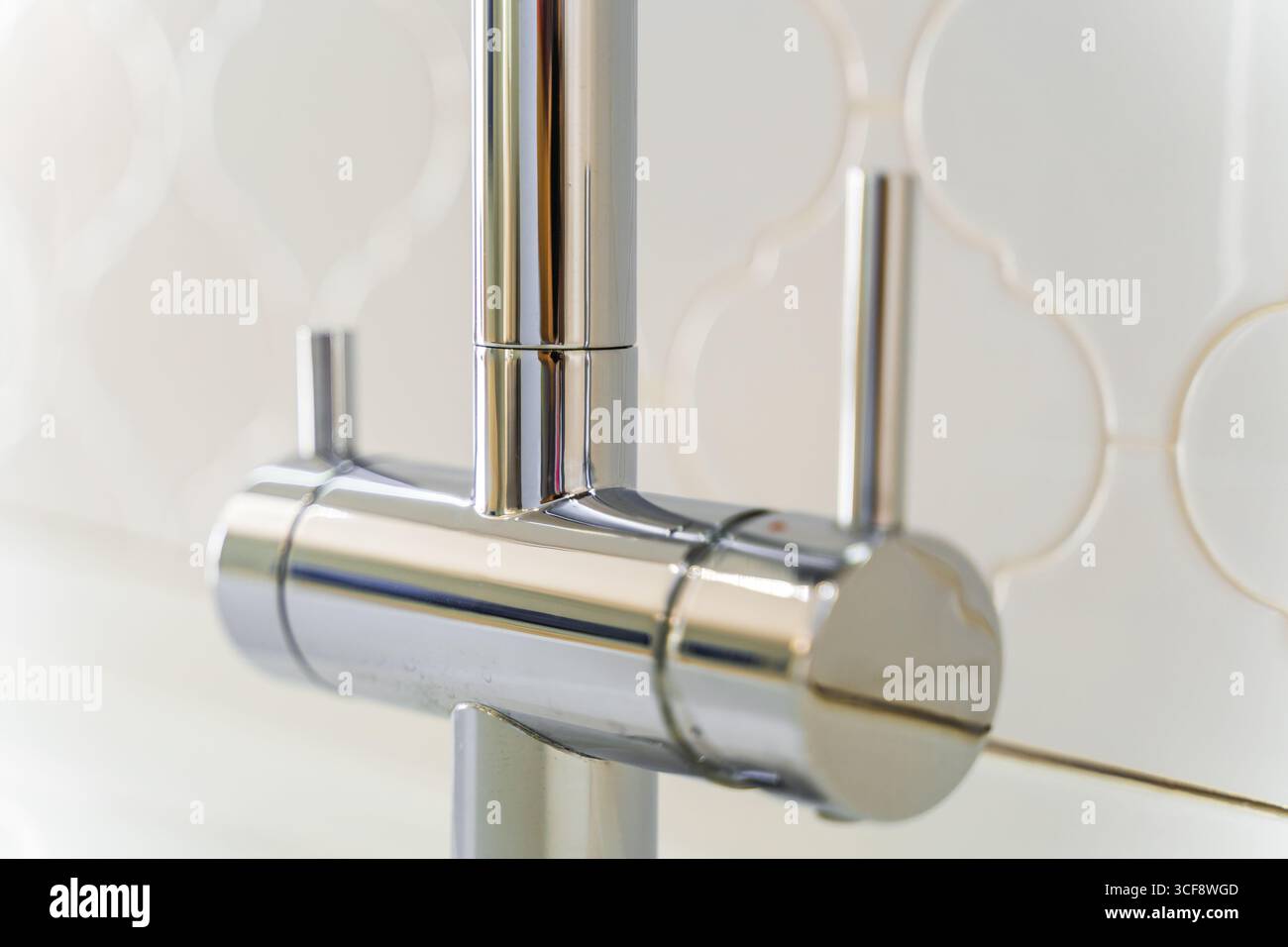 A white sink with a silver faucet and a microwave above it. The sink is ...