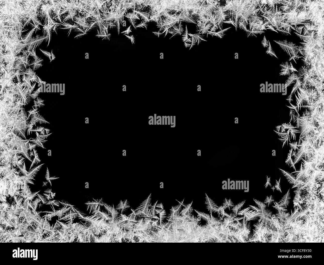 Beautiful white frost patterns arranged as frame on black background ...