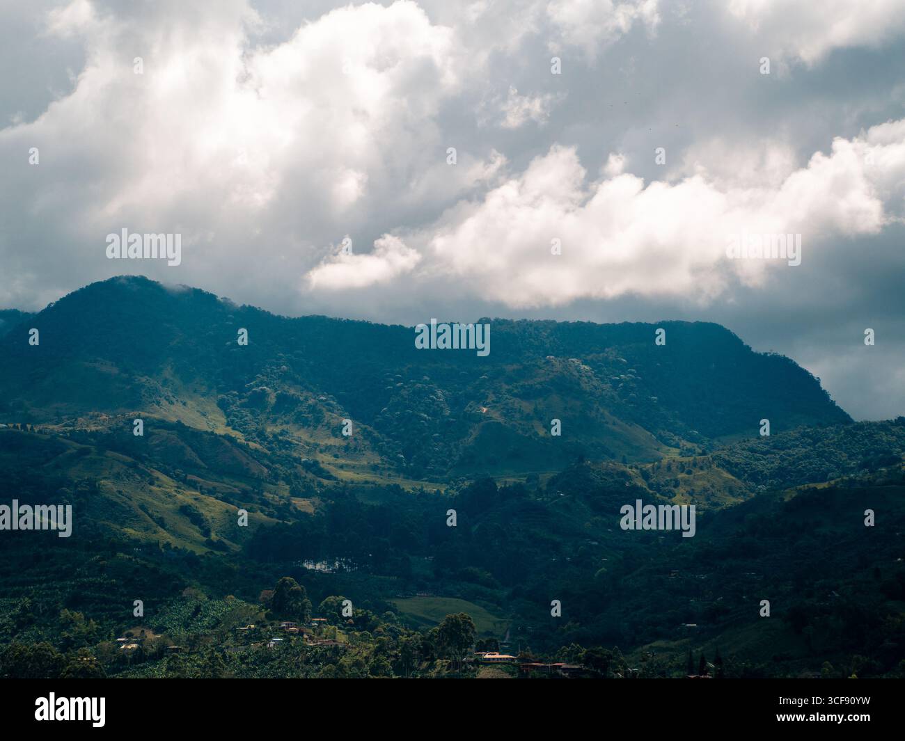 Colombian hills covered with green trees, daylight with dramatic clouds ...