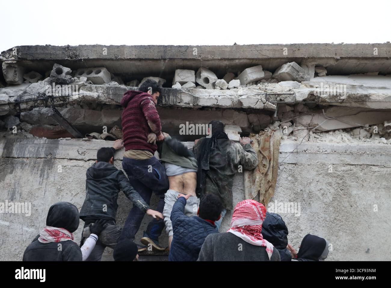 Civil defense teams attempt to rescue civilians trapped under the ...