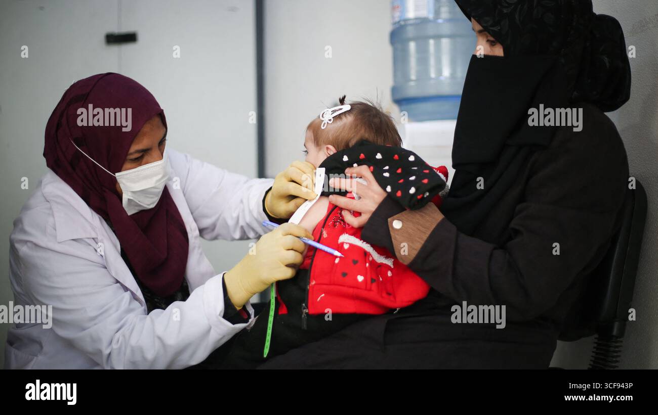 A doctor examines children's malnutrition inside a refugee camp ...