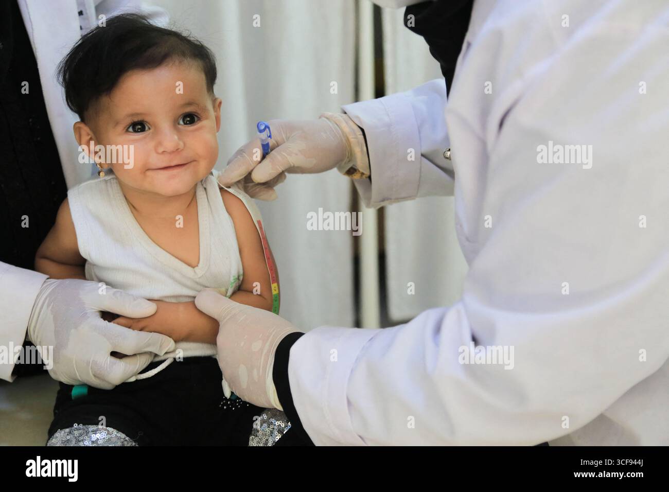 A doctor examines children's malnutrition inside a refugee camp ...