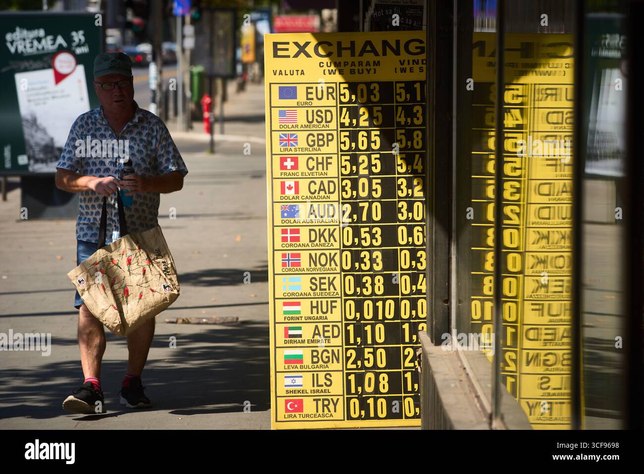 Bucharest, Romania. 21st Aug, 2025: People walk past a currency ...