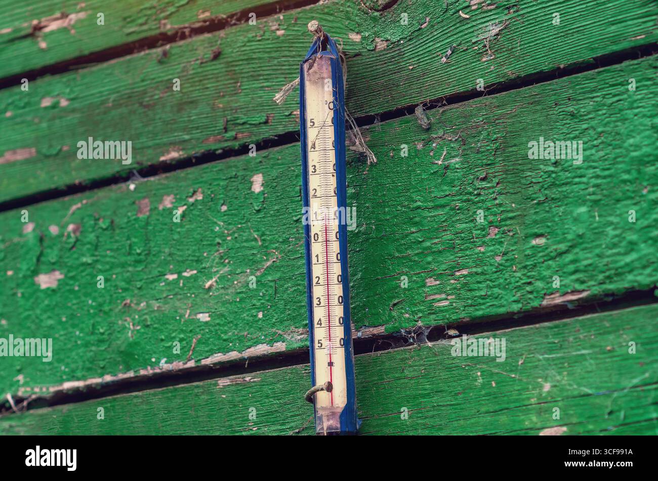 Thermometer for measuring air temperature on a painted green cracked ...