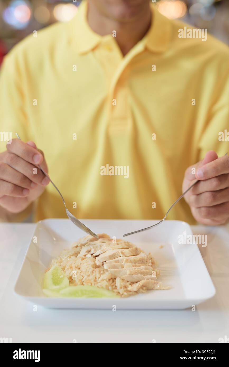 Close-up of man sitting at food court restaurant eating healthy ...