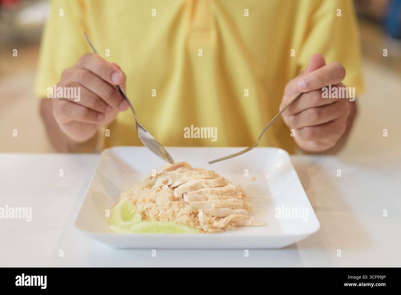 Close-up of man sitting at food court restaurant eating healthy ...