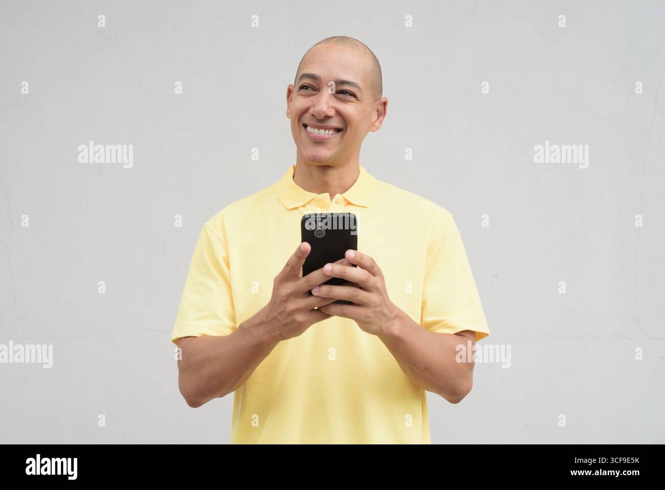 Studio portrait of a handsome mature happy Italian man with shaved head ...