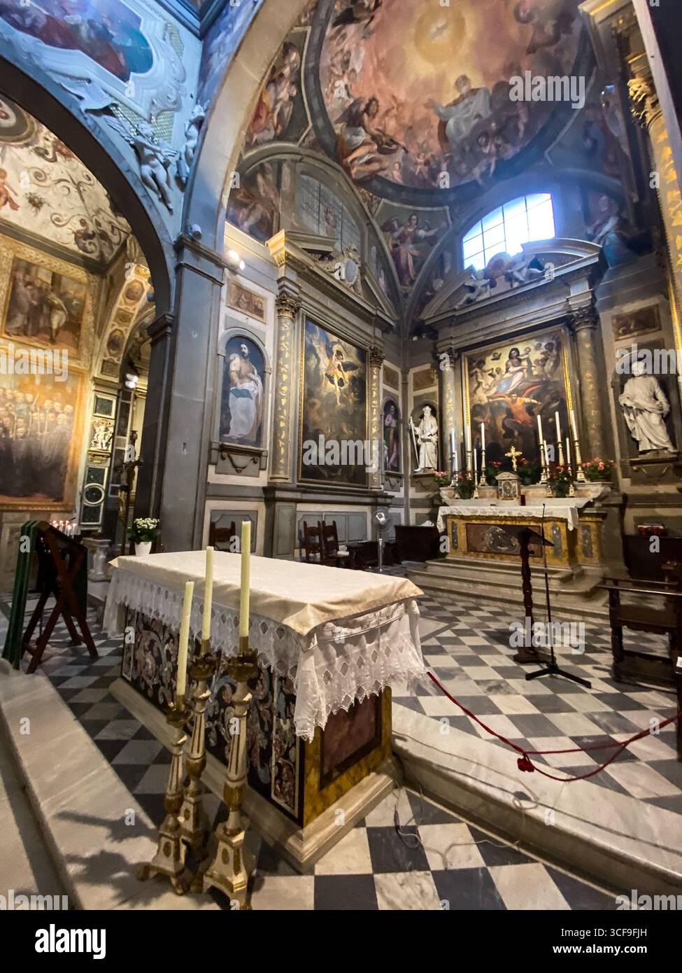 Ornate altar, vibrant frescoes, and checkered floor create a ...
