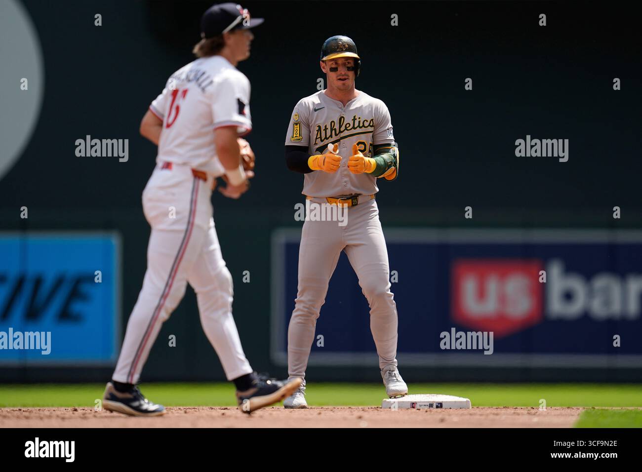 Athletics' Brent Rooker (25), right, gestures next to Minnesota Twins ...