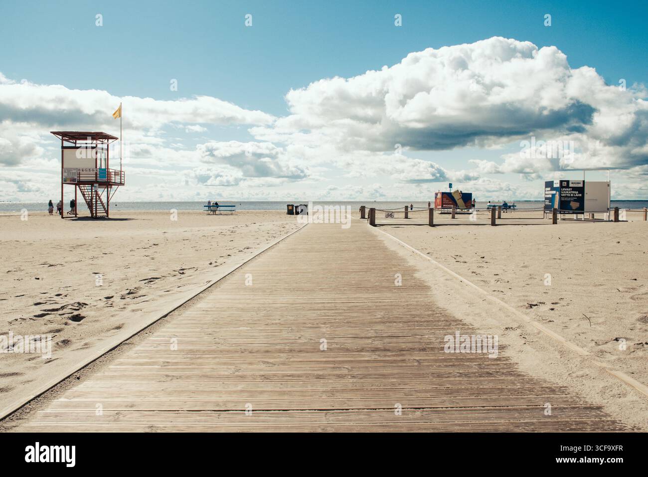 Wide, sandy beach with a wooden walkway leading to the shore. There are ...