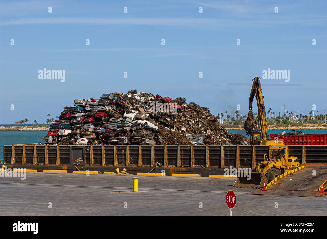 Claw arm tracked excavator on barge loading trucks with scrap metal for ...