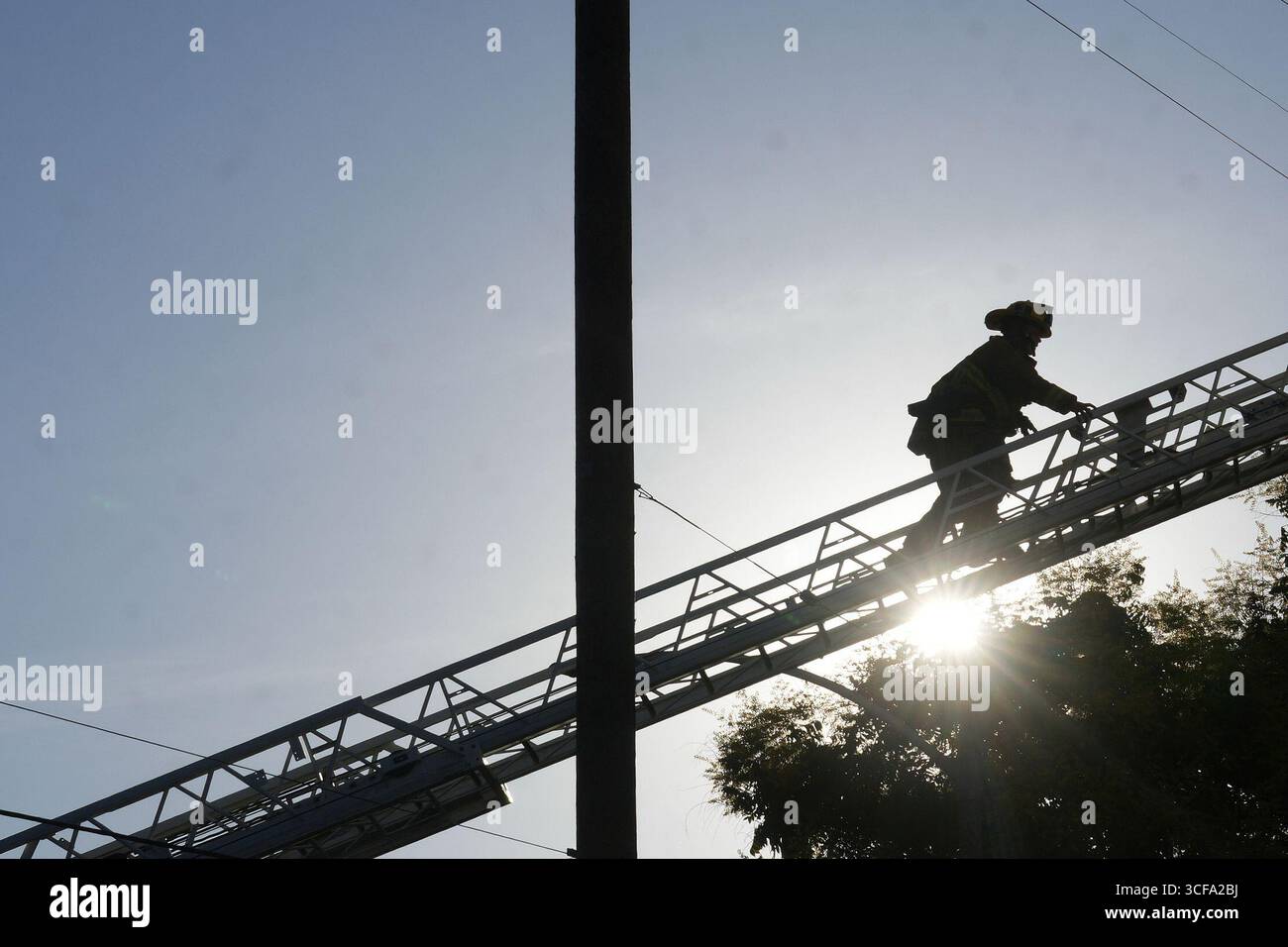 A firefighter climbs up a ladder while fighting a fire on Thursday, Aug ...